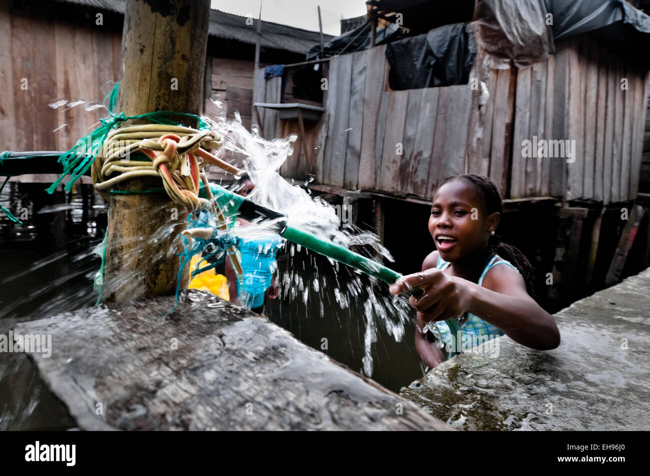 A Colombian girl fills plastic barrels with safe drinking water inside ...