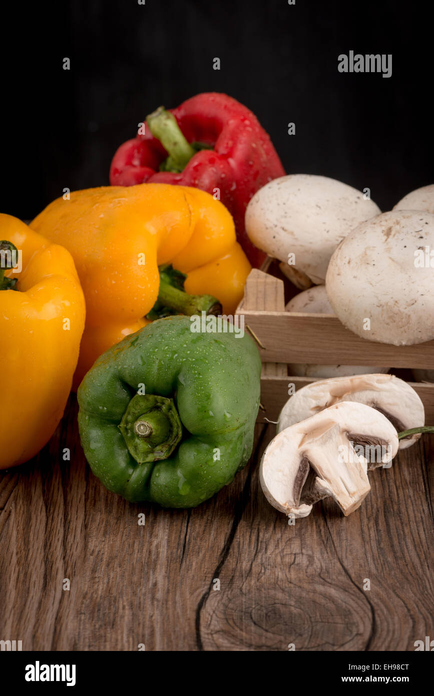Colored bell peppers on old wooden table Stock Photo - Alamy
