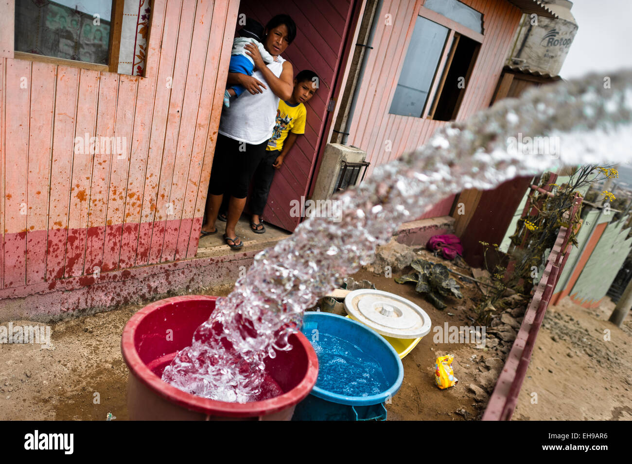 A splashing stream of drinking water falls into a plastic barrel in ...