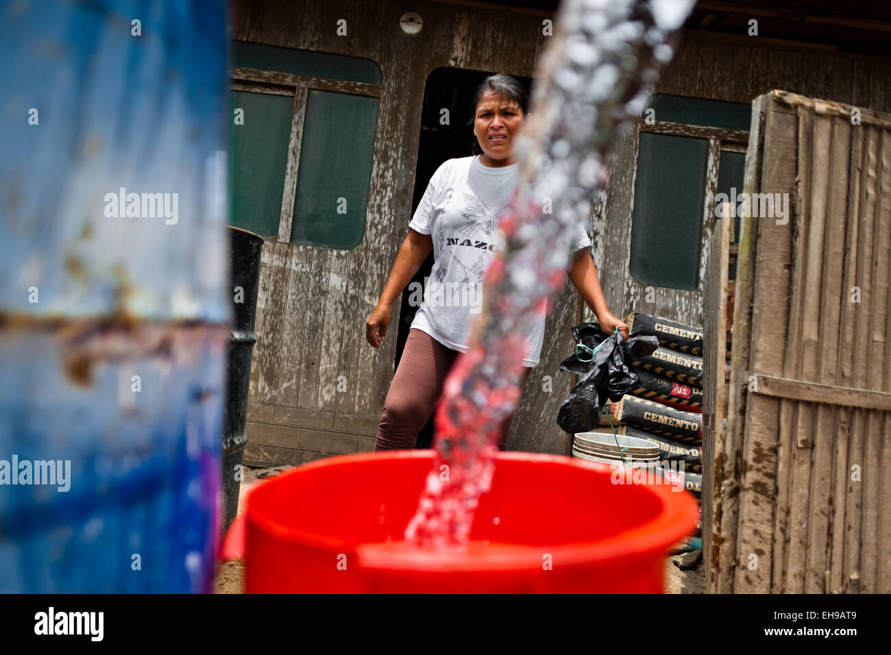 A splashing stream of drinking water falls into a plastic barrel in ...