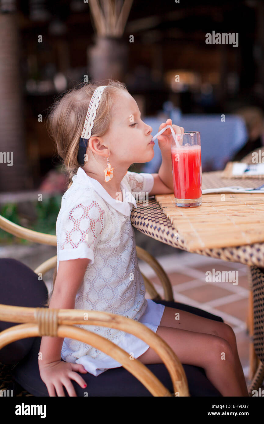 Adorable little girl drinking fruit cocktail outdoor Stock Photo - Alamy