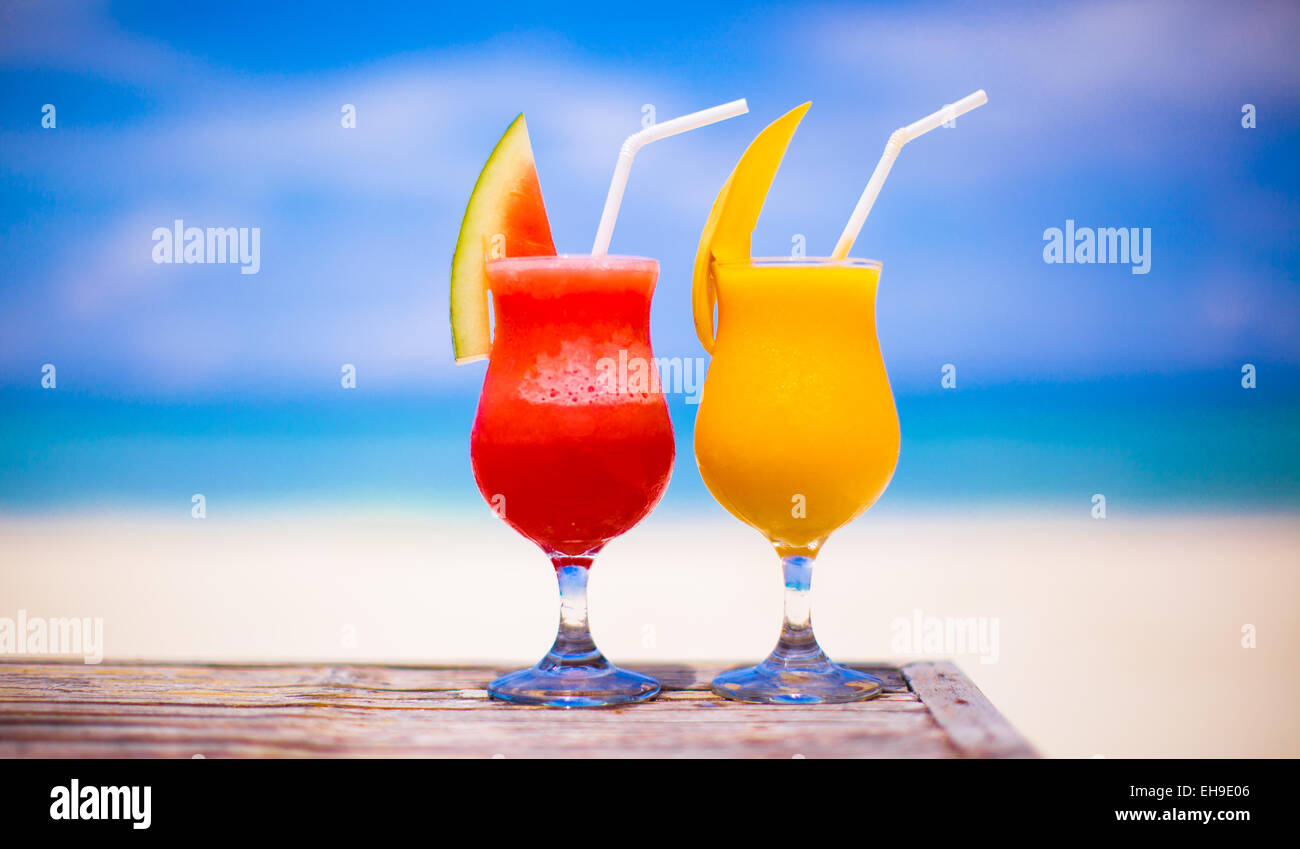 Two tasty fruits cocktails on background of turquoise sea Stock Photo ...