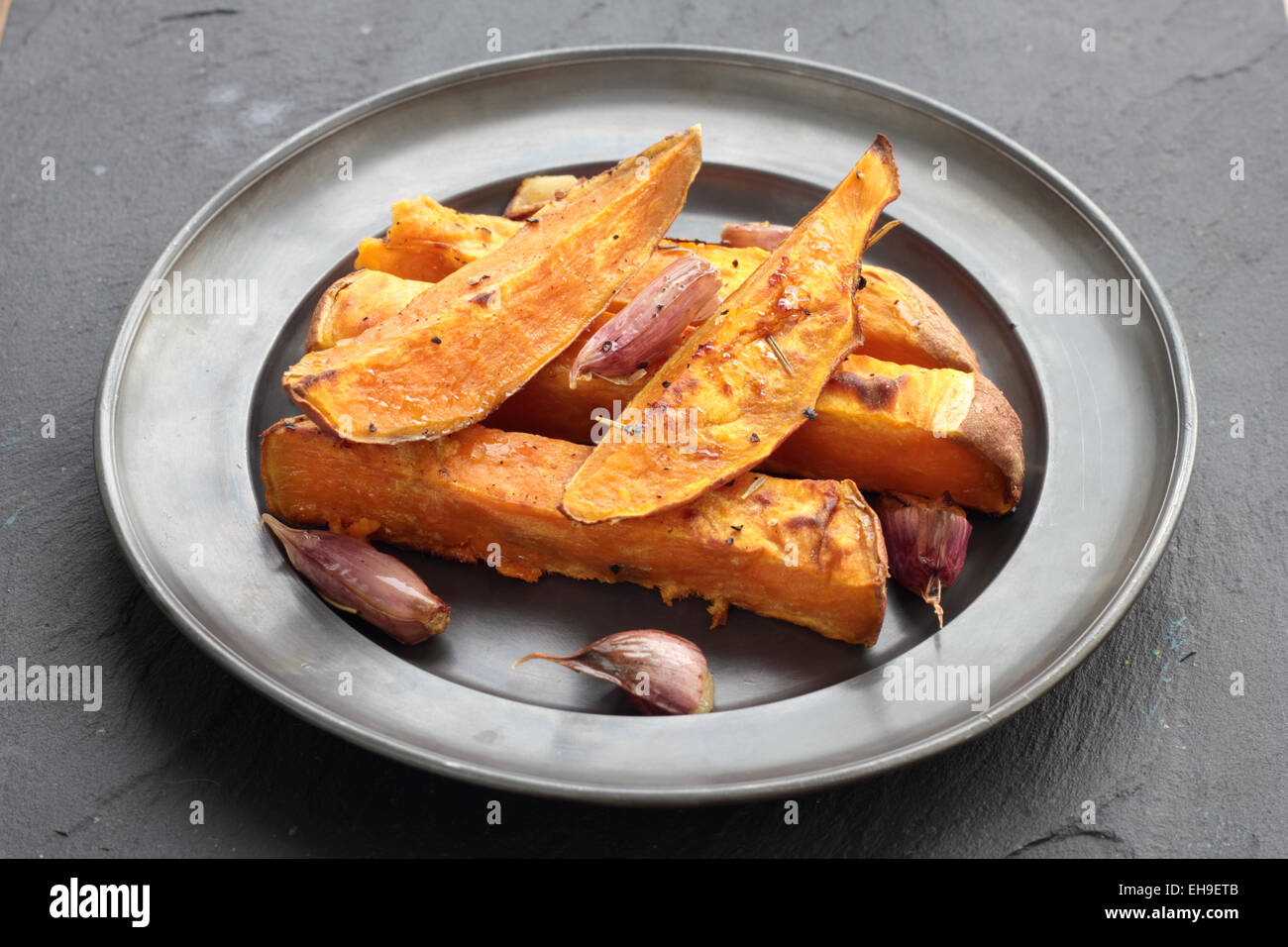 Sweet potato roasted chips on a tin plate Stock Photo - Alamy