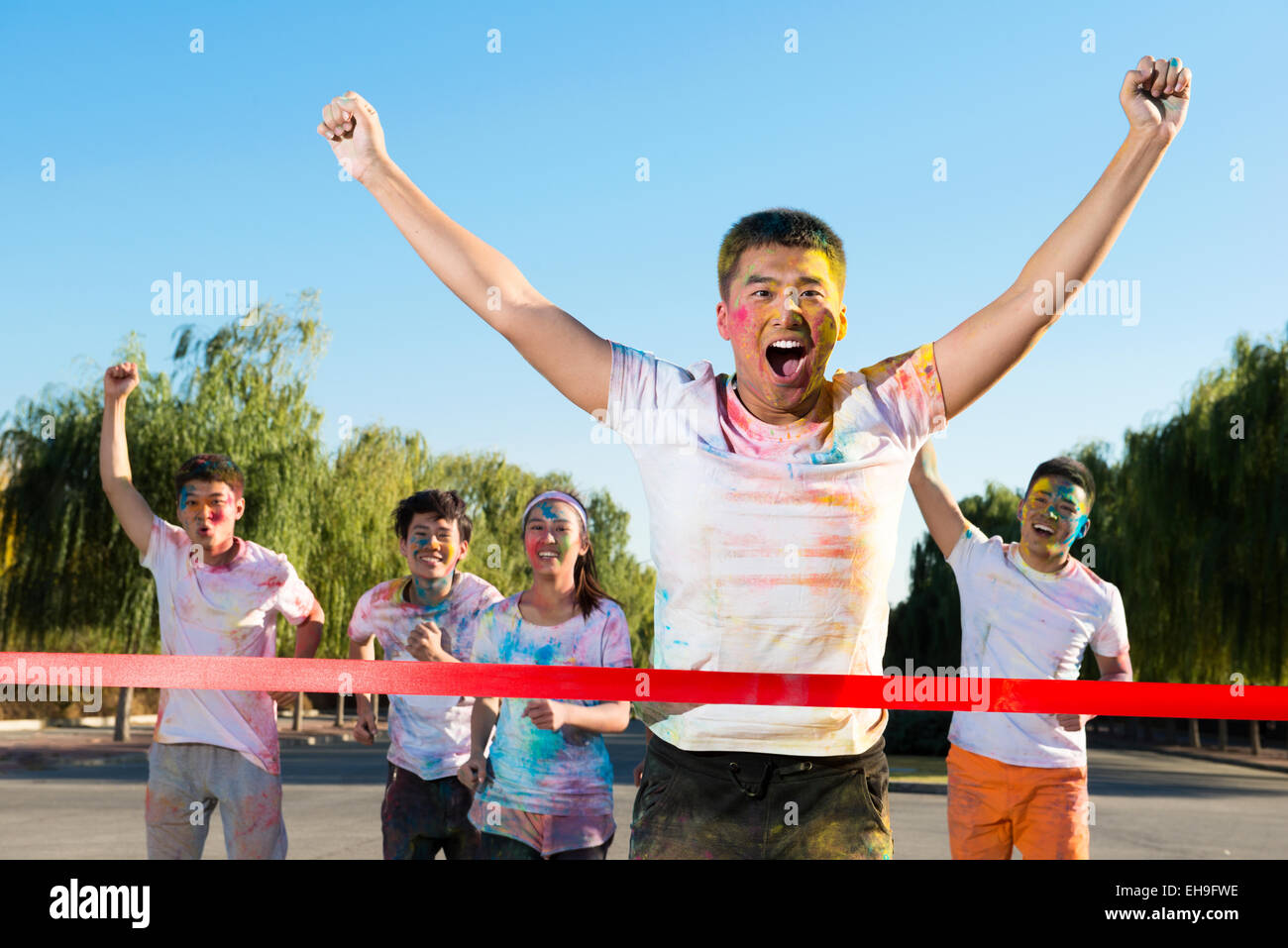 Young man crossing finishing line at The Color Run Stock Photo - Alamy