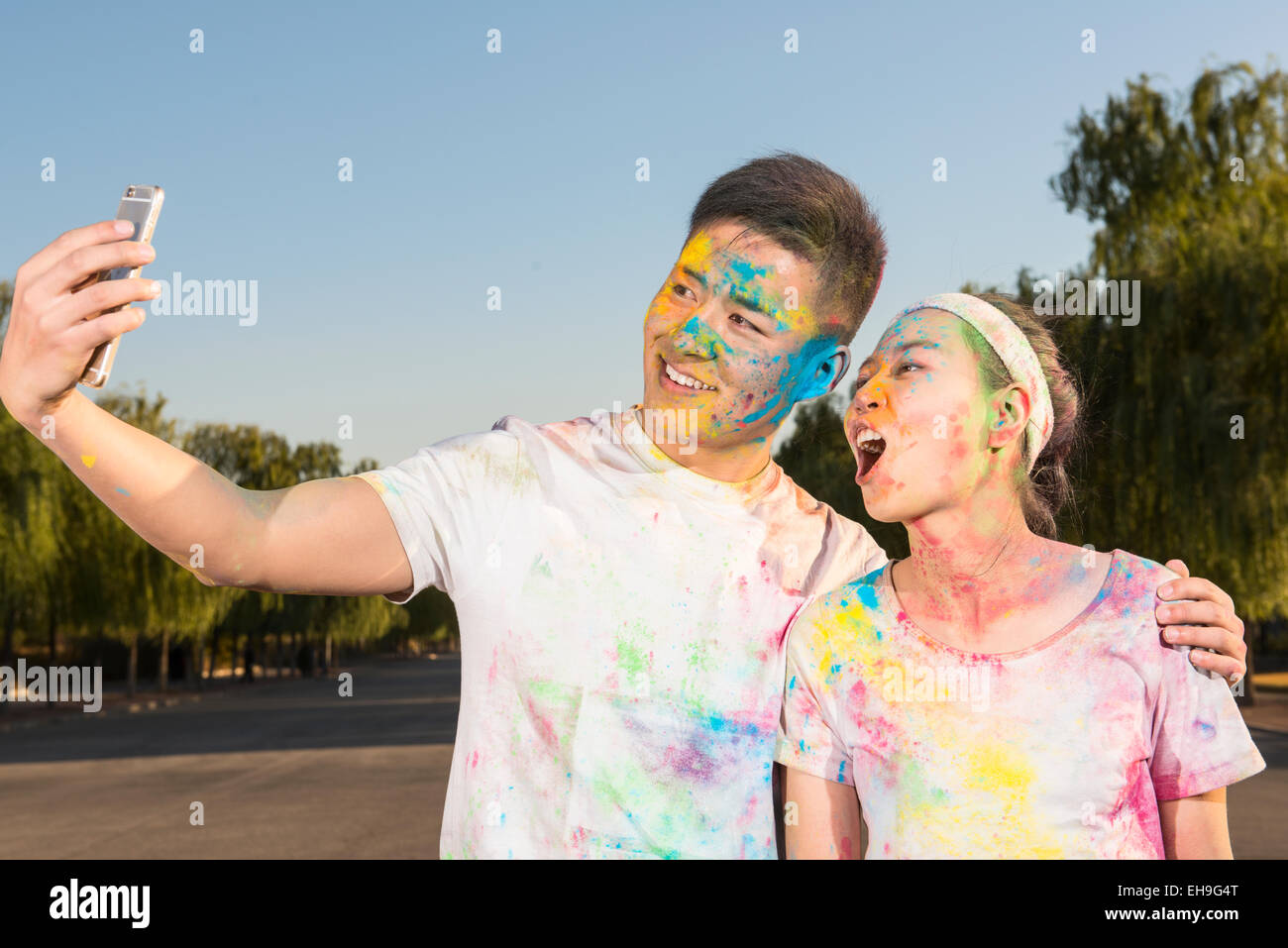 Couple taking selfie at The Color Run Stock Photo - Alamy