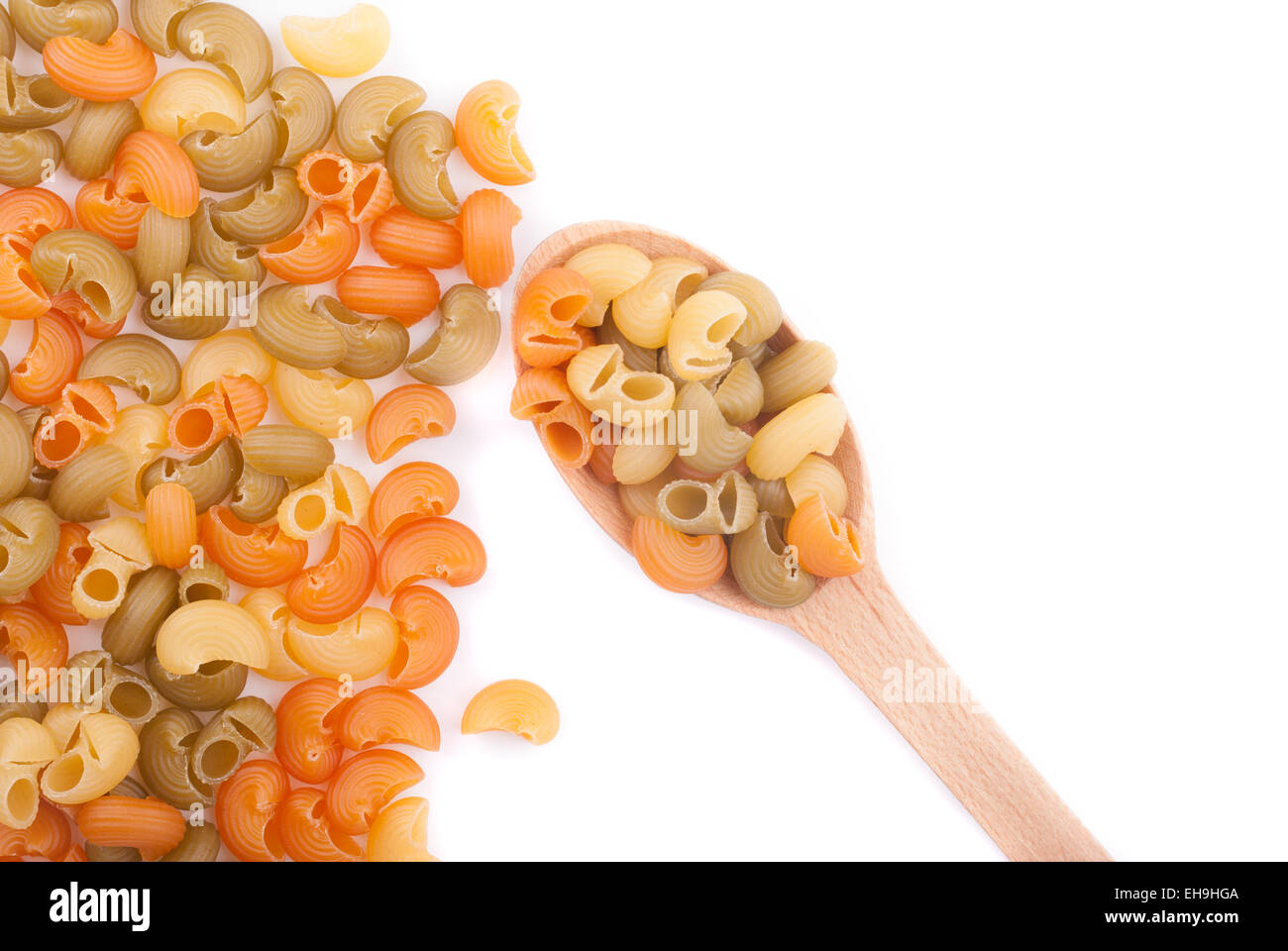Colored pasta and wooden spoon on a white background Stock Photo - Alamy