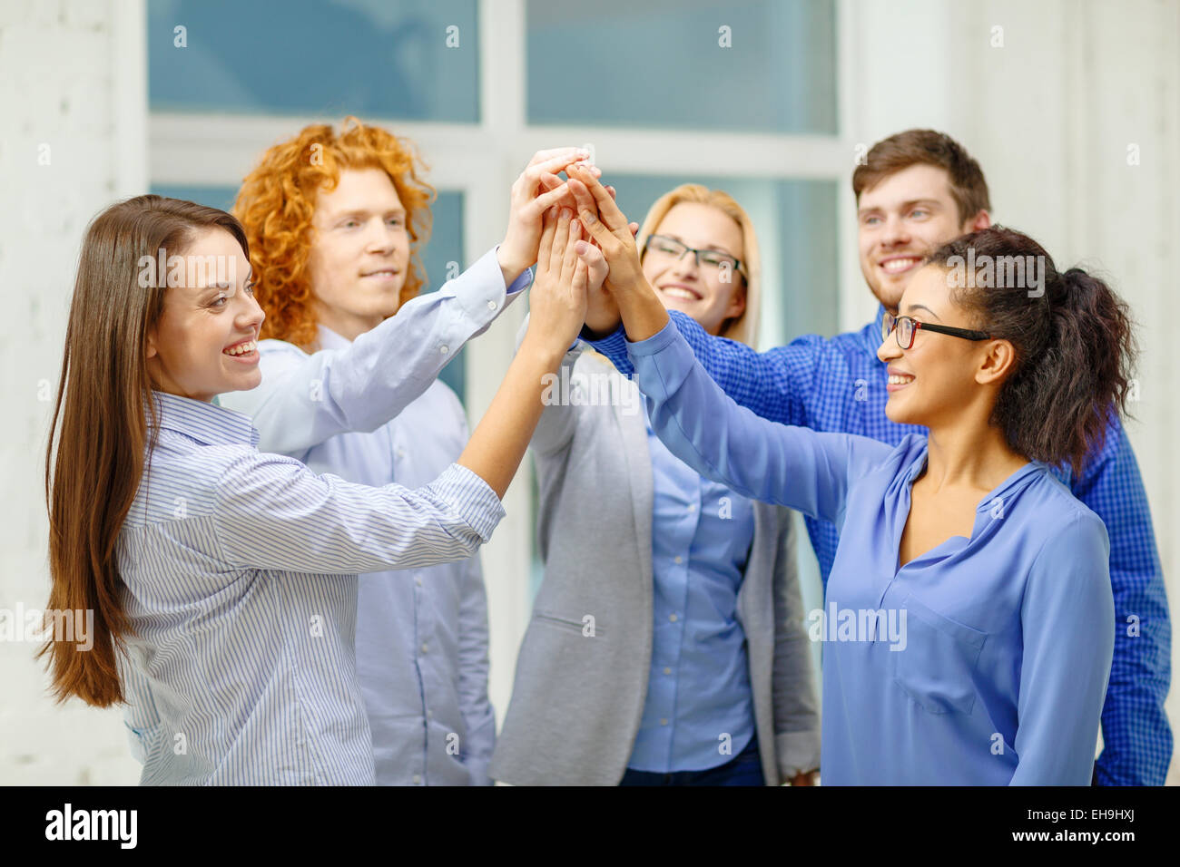 creative team doing high five gesture in office Stock Photo - Alamy