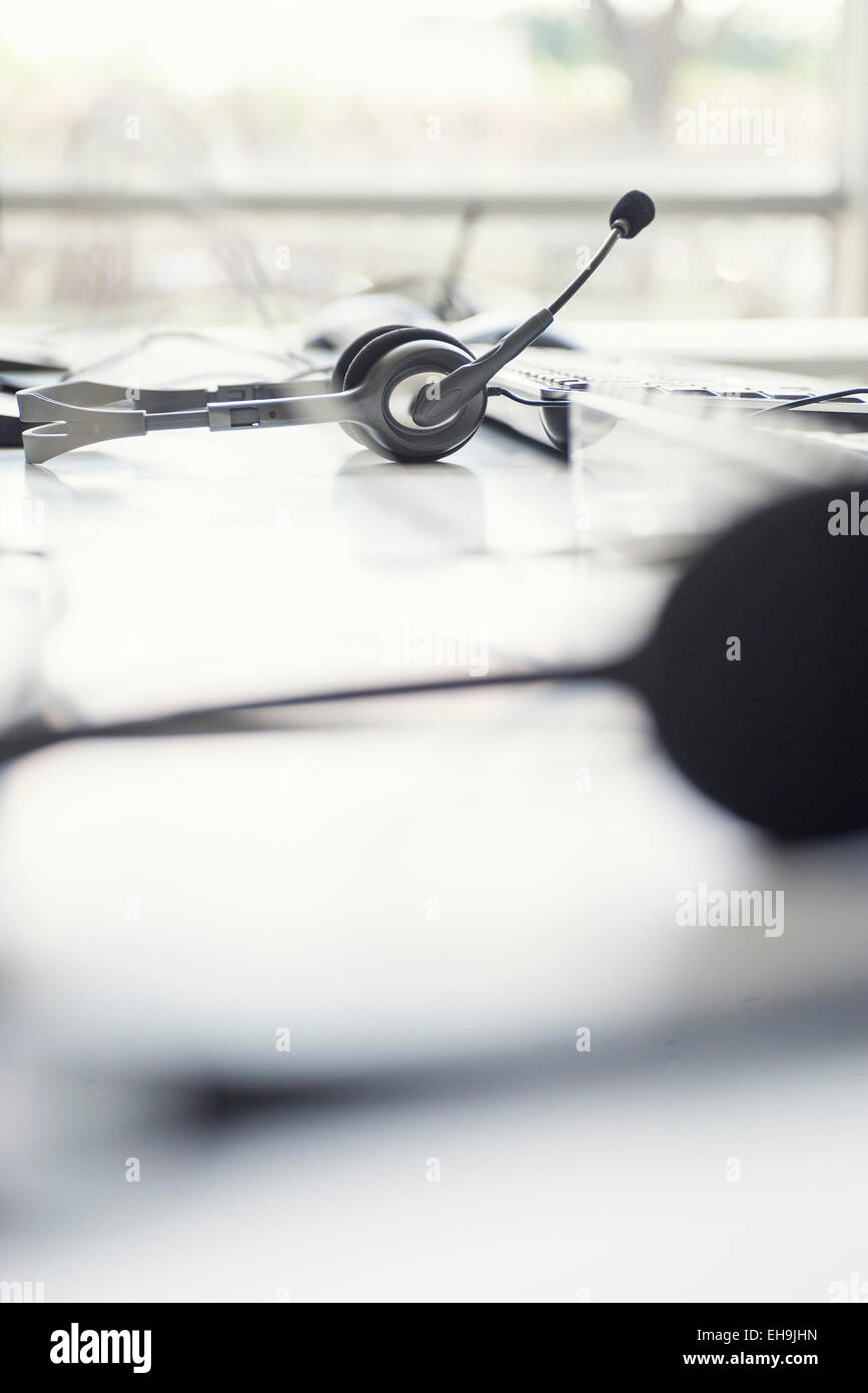Phone headset on desk Stock Photo - Alamy