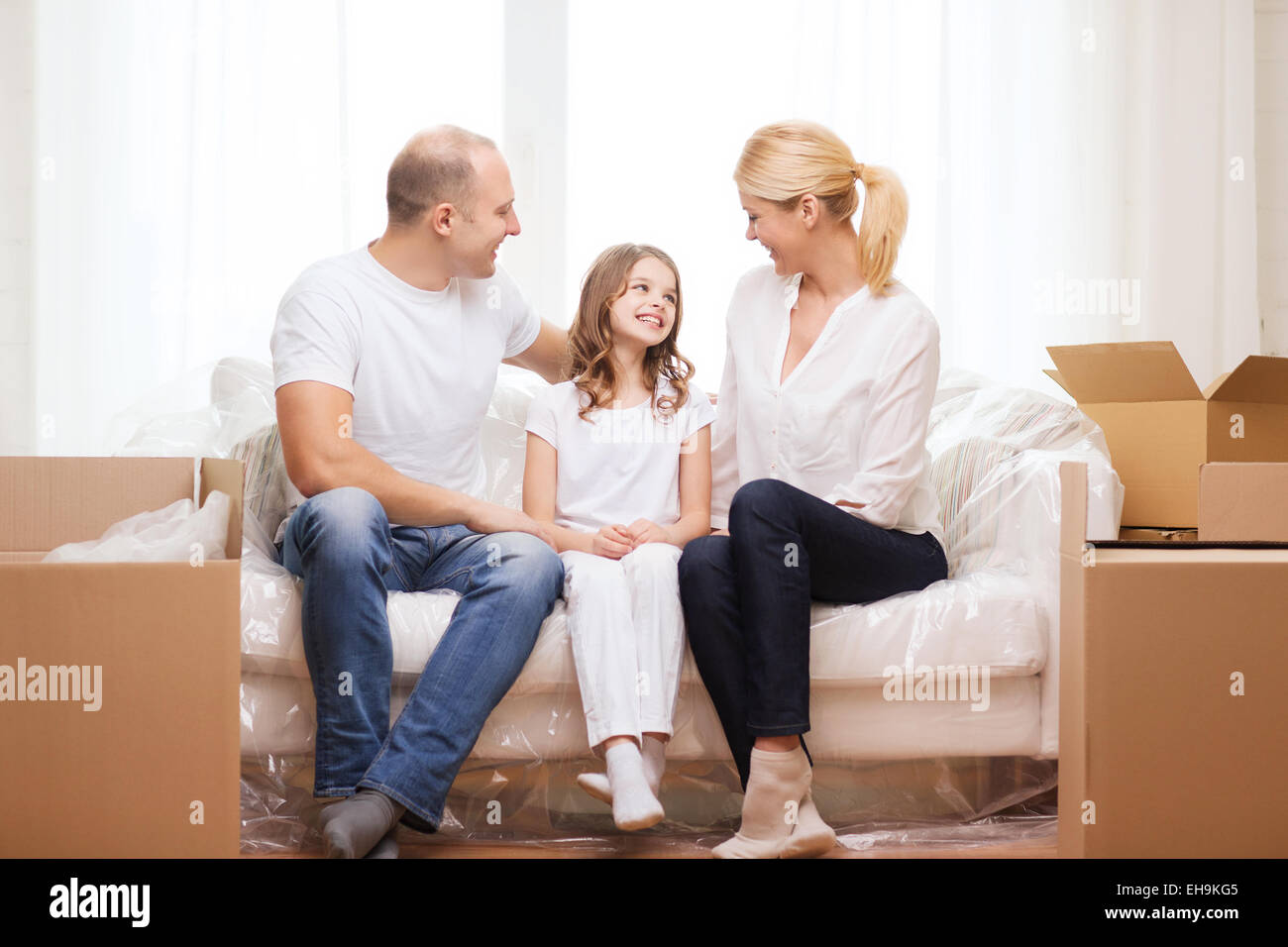smiling parents and little girl at new home Stock Photo - Alamy