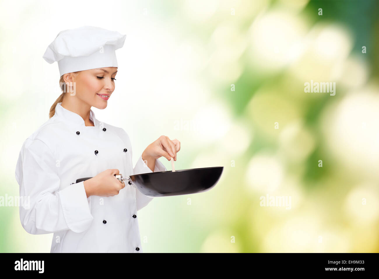 smiling female chef with pan and spoon Stock Photo - Alamy