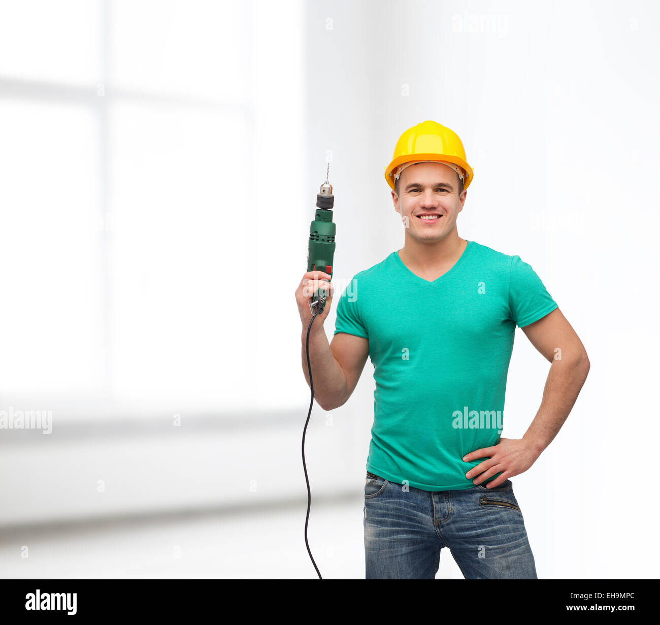 smiling manual worker in helmet with drill machine Stock Photo - Alamy