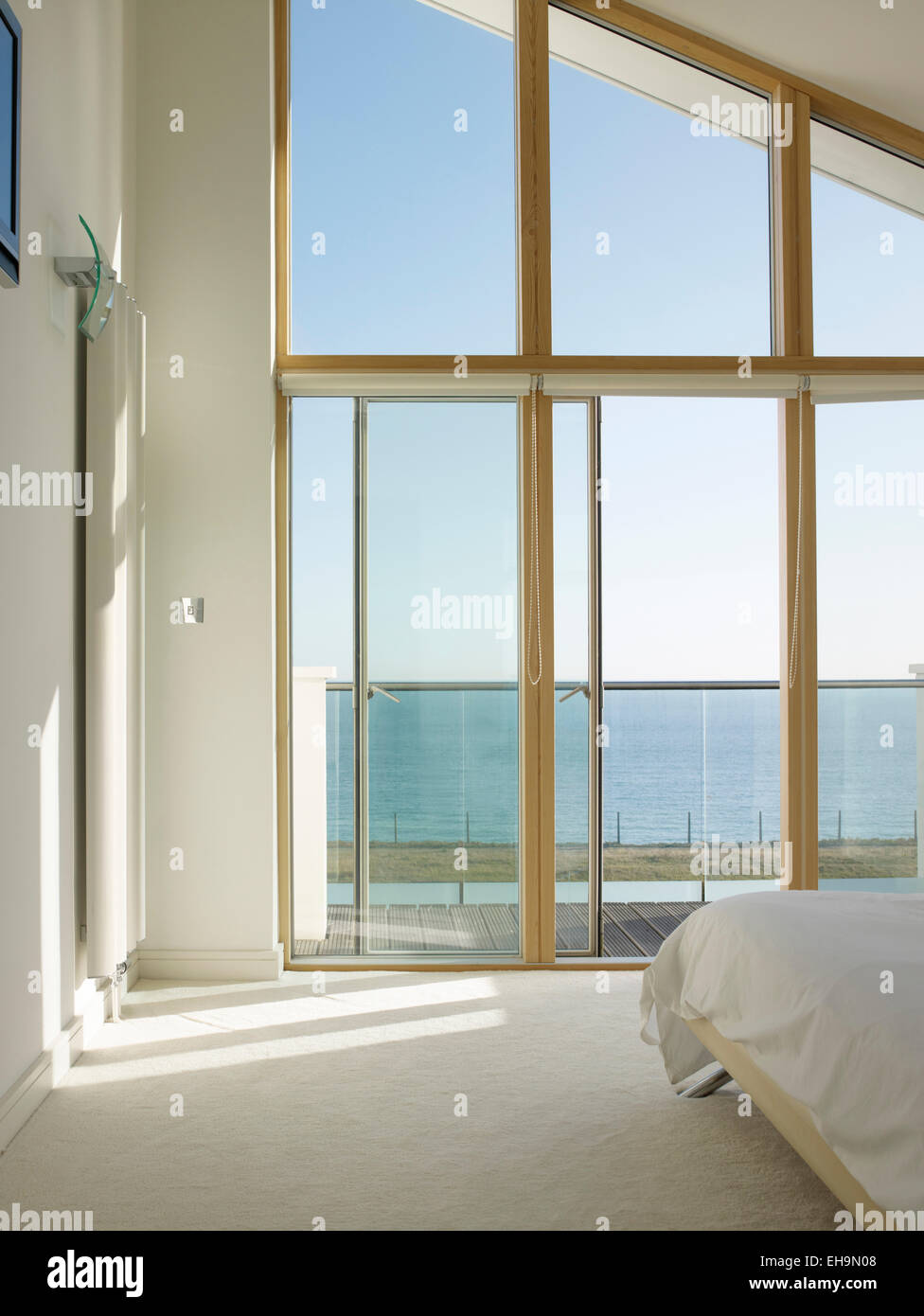 White bedroom with picture window and sliding glass door, residential ...