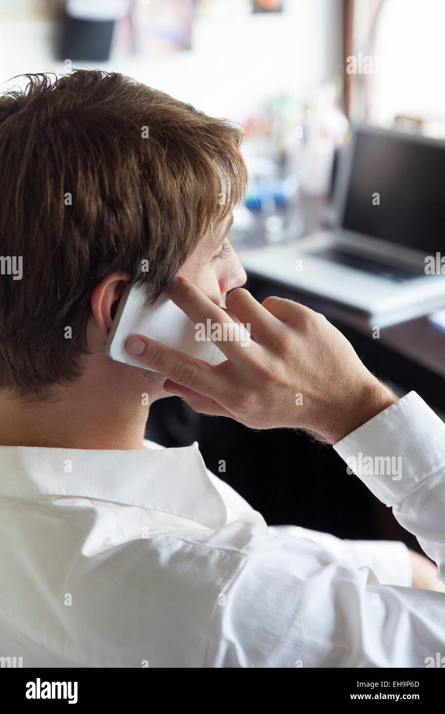 Office worker using cell phone, side view Stock Photo - Alamy
