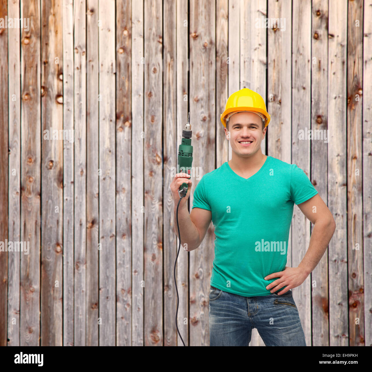 smiling manual worker in helmet with drill machine Stock Photo - Alamy