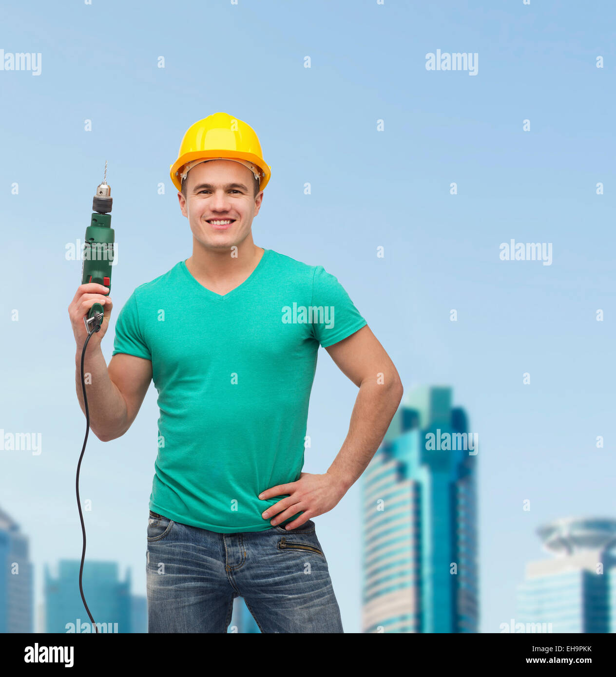 smiling manual worker in helmet with drill machine Stock Photo - Alamy