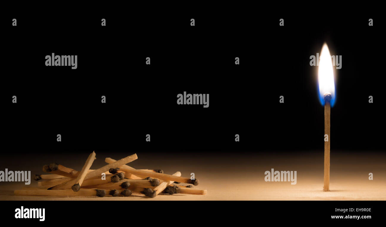 Pile of burnt matches laying down in front of one burning match ...