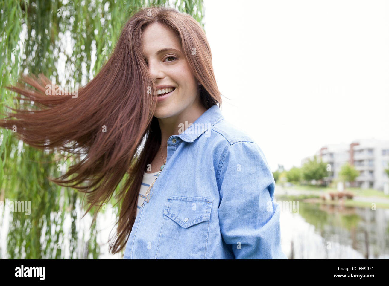 Young woman tossing her hair outdoors Stock Photo - Alamy