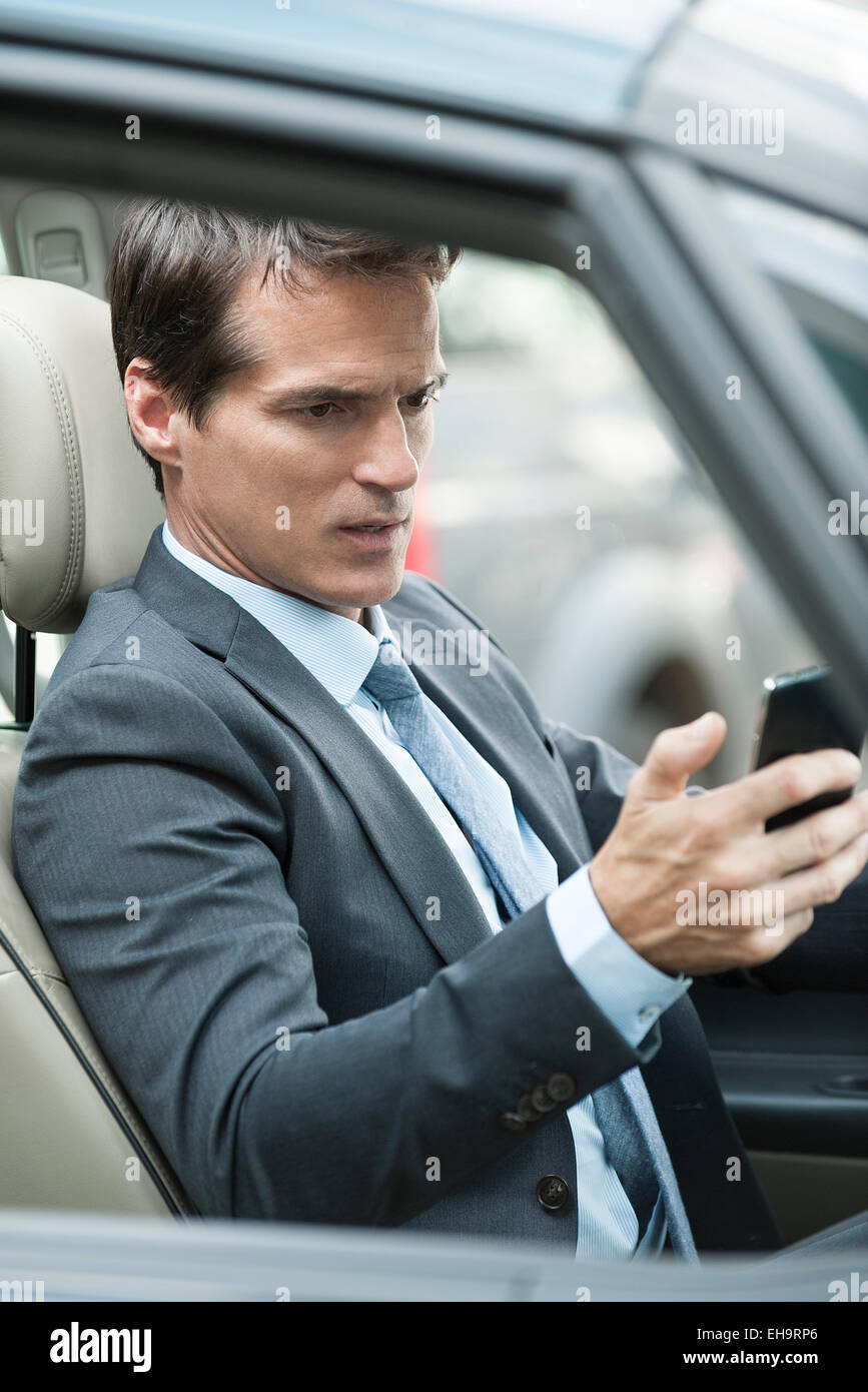 Man reading text message while driving Stock Photo - Alamy