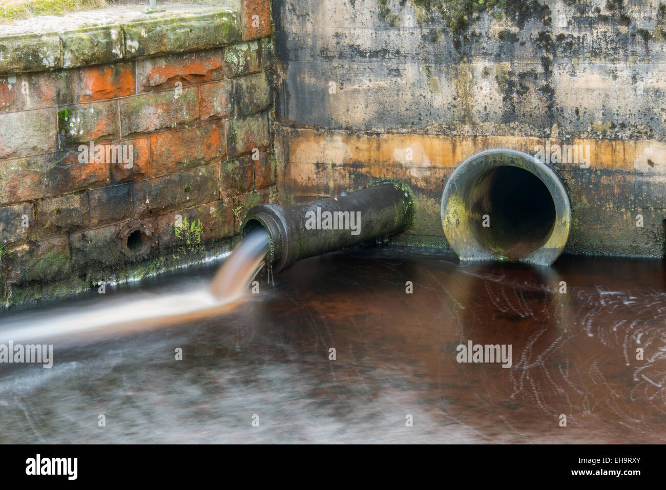 An overflow pipe at a water treatment works spewing water in to a ...