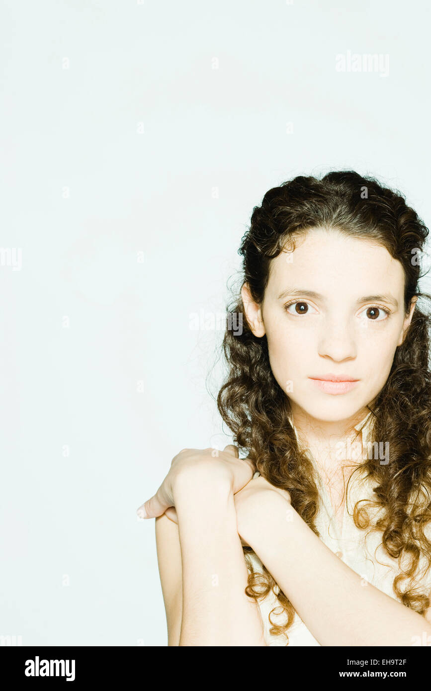 Young woman with hands clasped on shoulder, portrait Stock Photo - Alamy