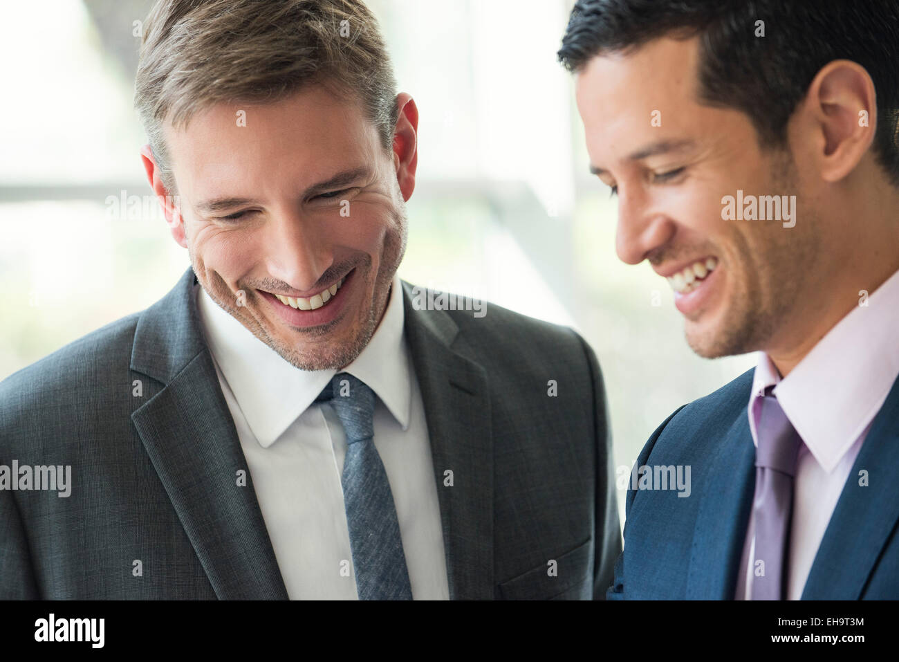Businessmen talking and laughing together Stock Photo - Alamy