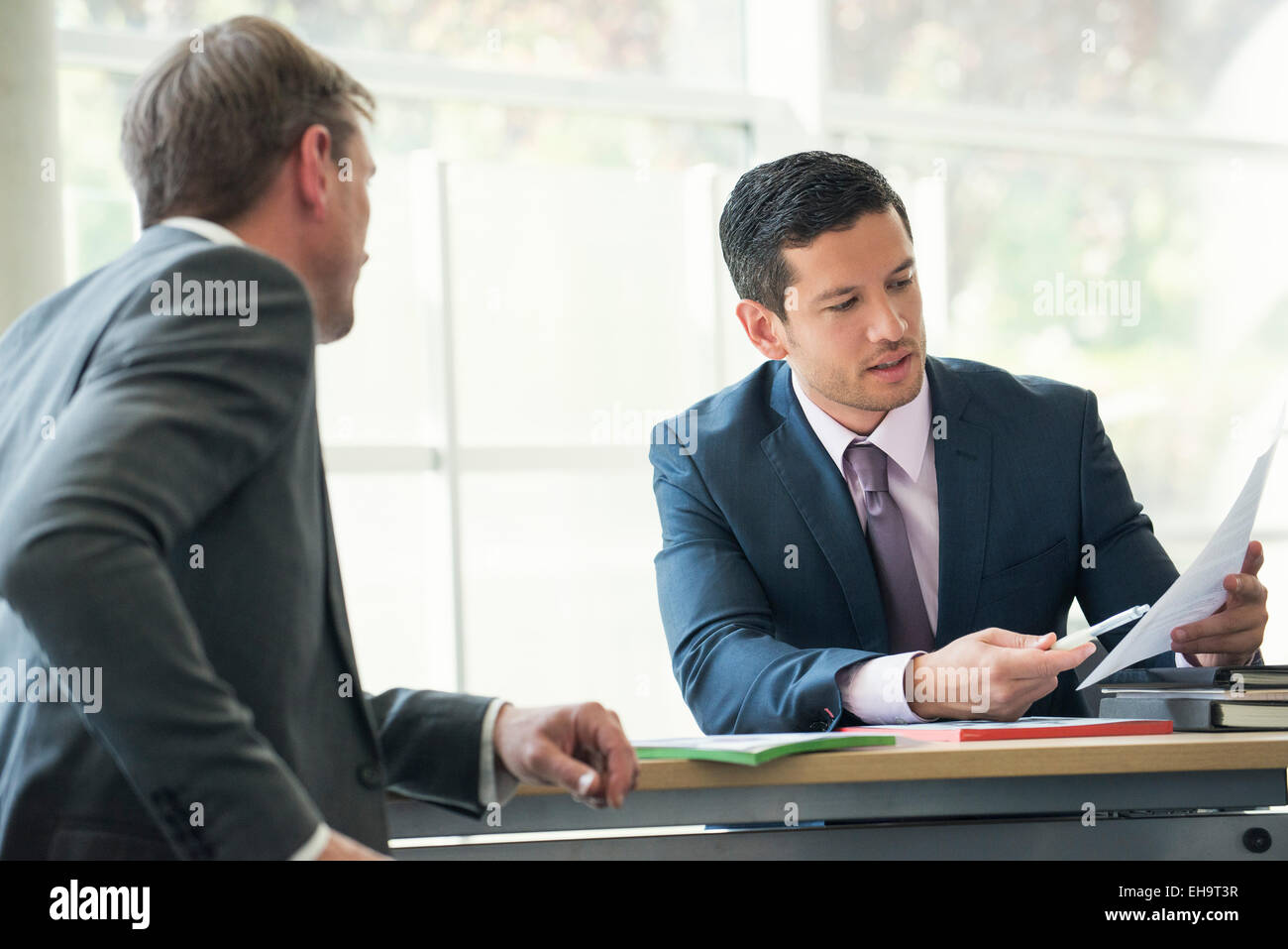 Businessmen discussing contract in meeting Stock Photo - Alamy