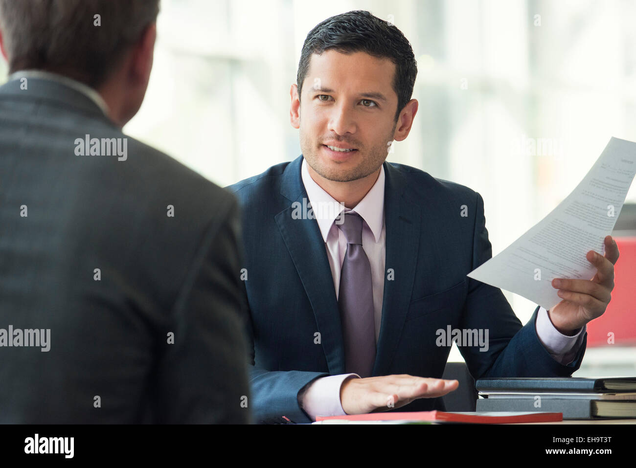 Businessman discussing contract with client Stock Photo - Alamy