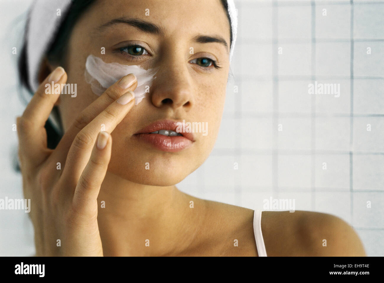 Young woman moisturizing face, close-up Stock Photo - Alamy