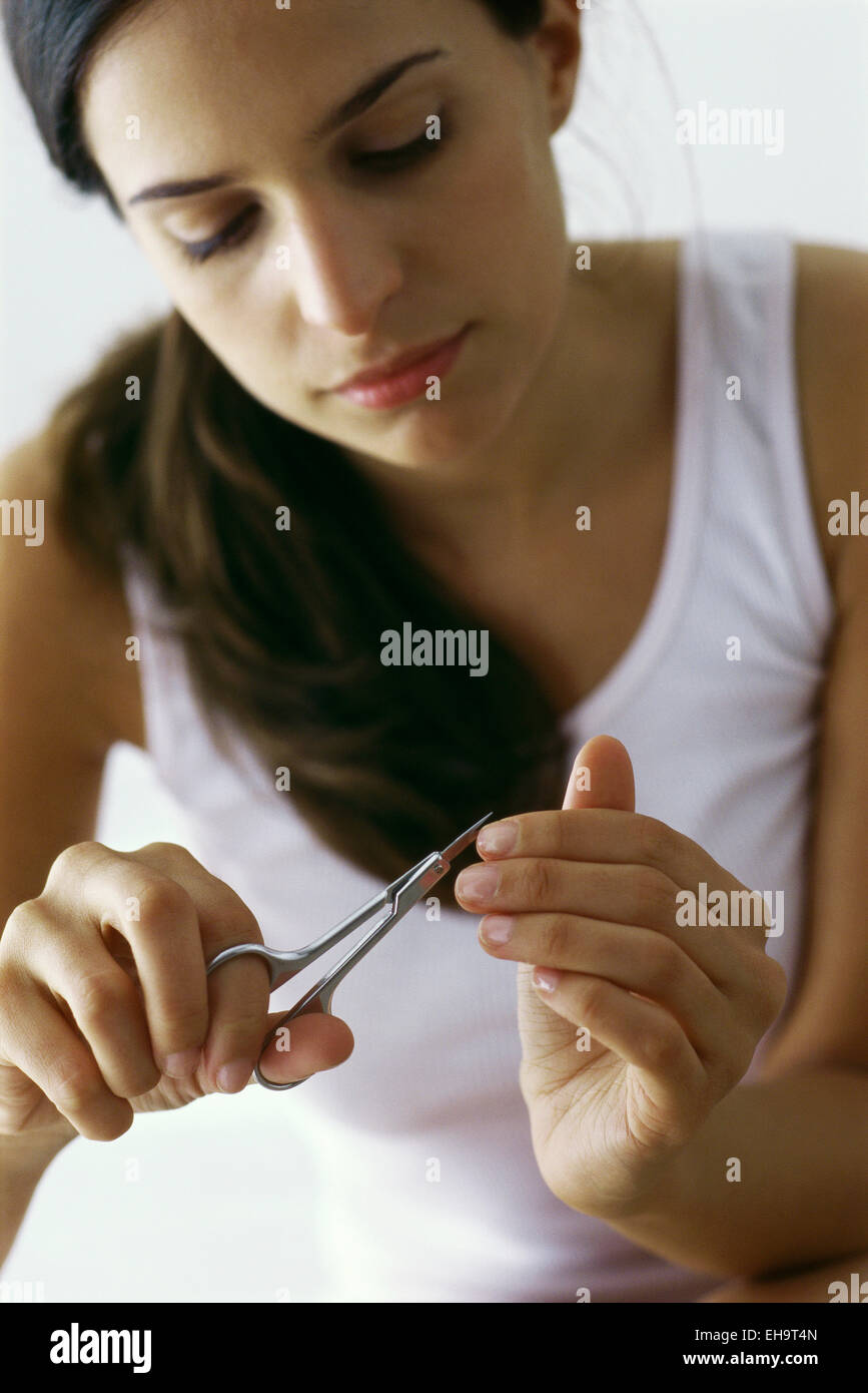 Young woman trimming finger nails with nail scissors, close-up Stock ...