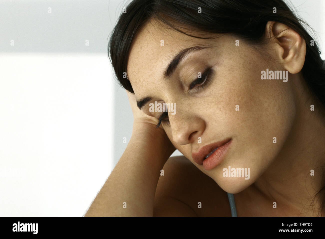 Woman holding head, looking down, portrait Stock Photo - Alamy