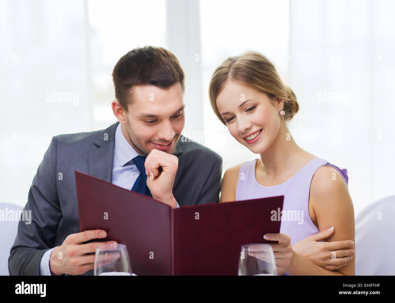 smiling couple with menu at restaurant Stock Photo - Alamy