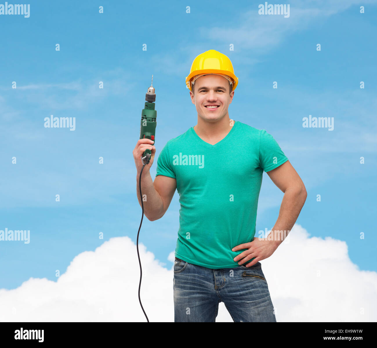 smiling manual worker in helmet with drill machine Stock Photo - Alamy