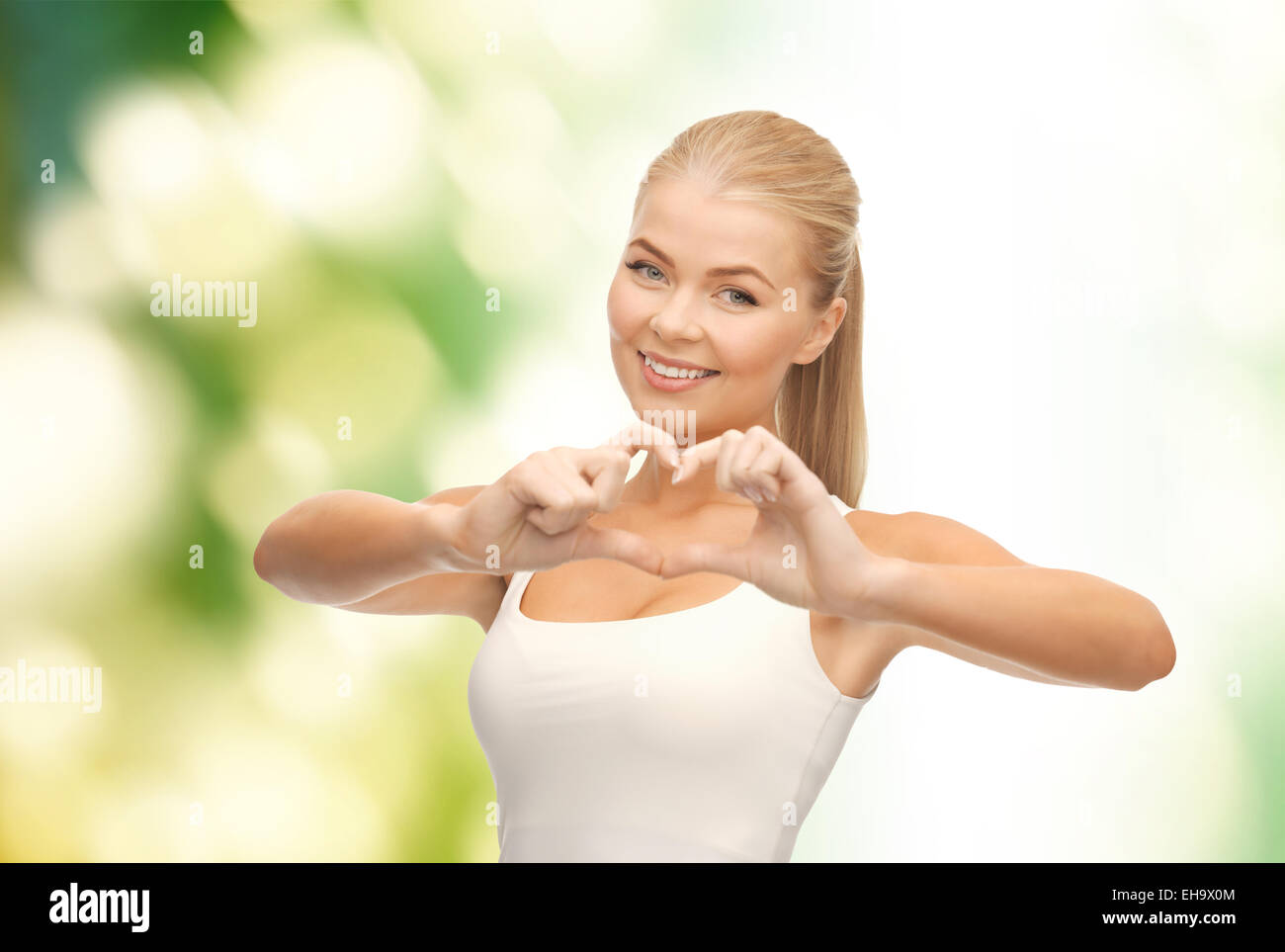 smiling woman showing heart shape gesture Stock Photo - Alamy