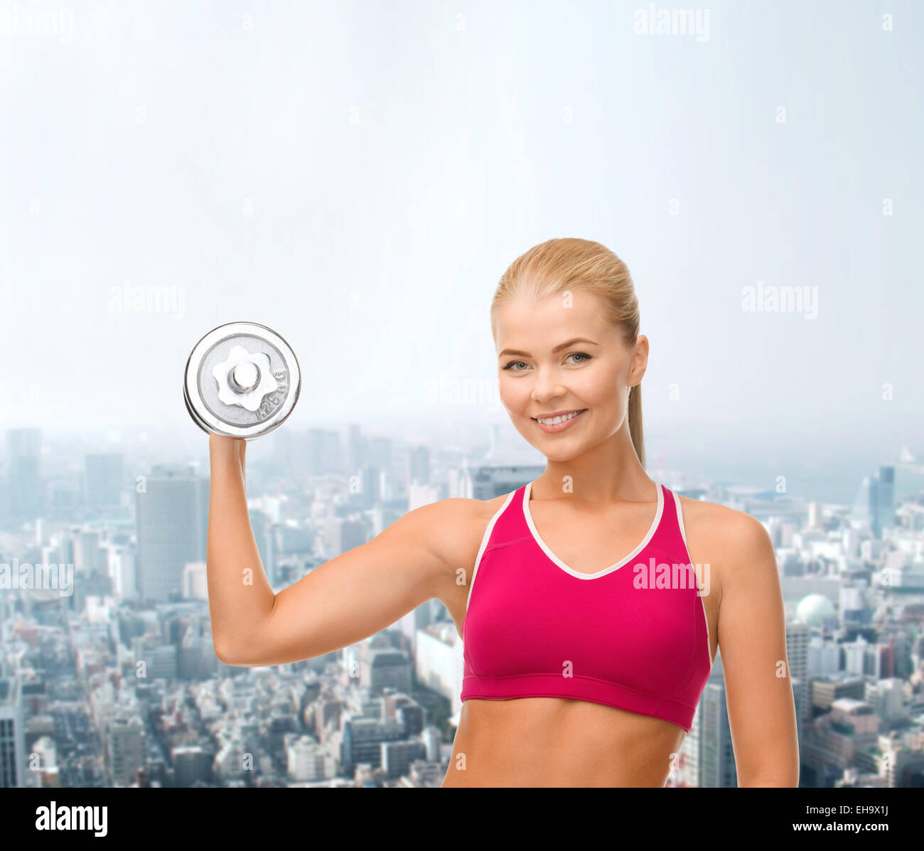 smiling woman with heavy steel dumbbell Stock Photo - Alamy