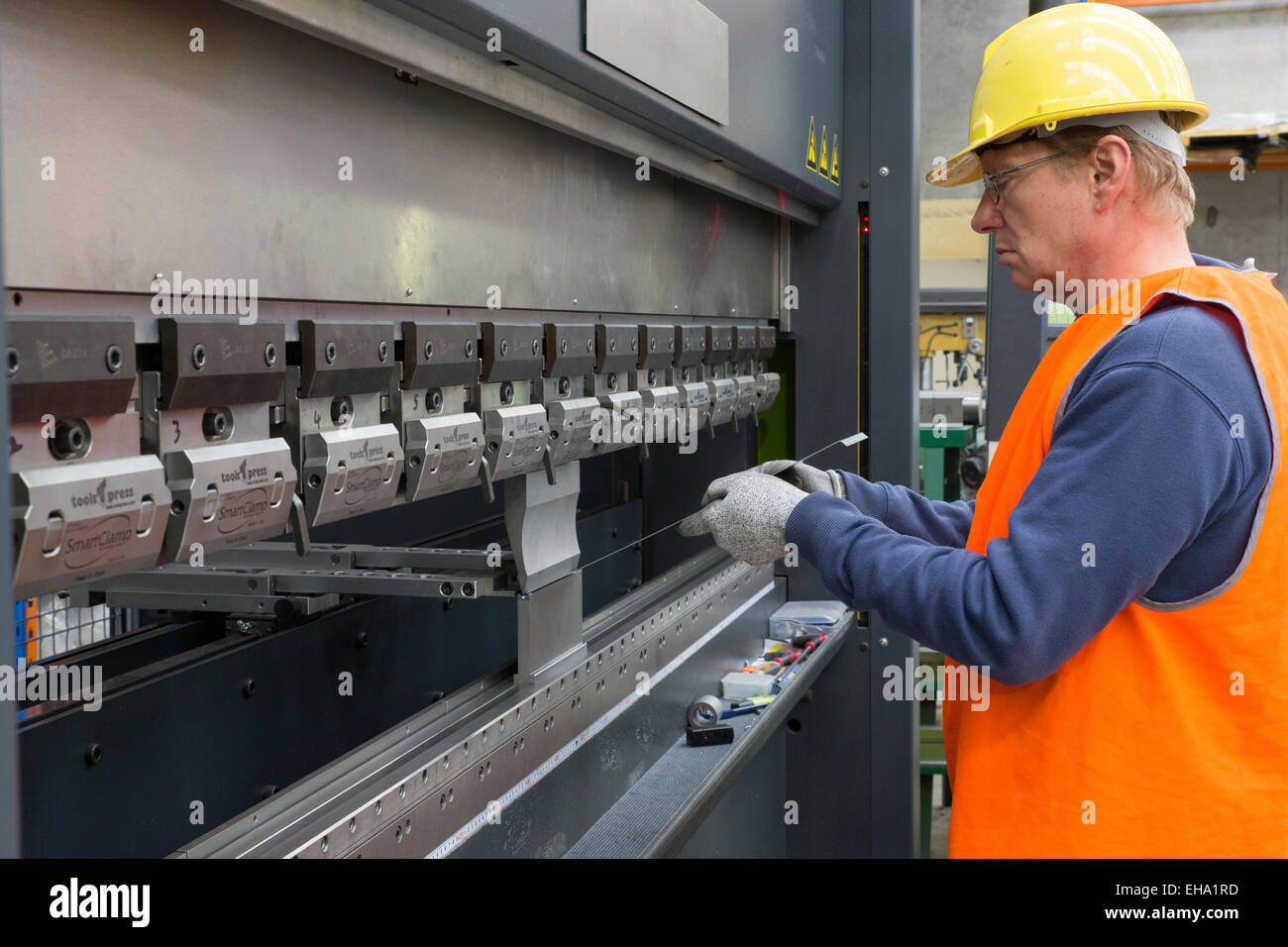 metal industry worker operates CNC brake press machine Stock Photo - Alamy