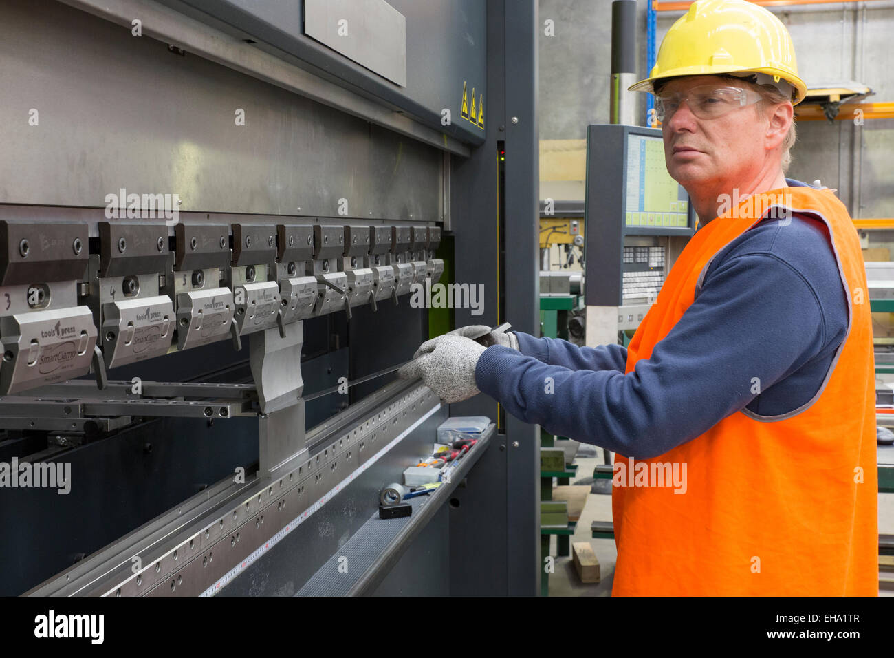 metal industry worker operates CNC brake press machine Stock Photo - Alamy