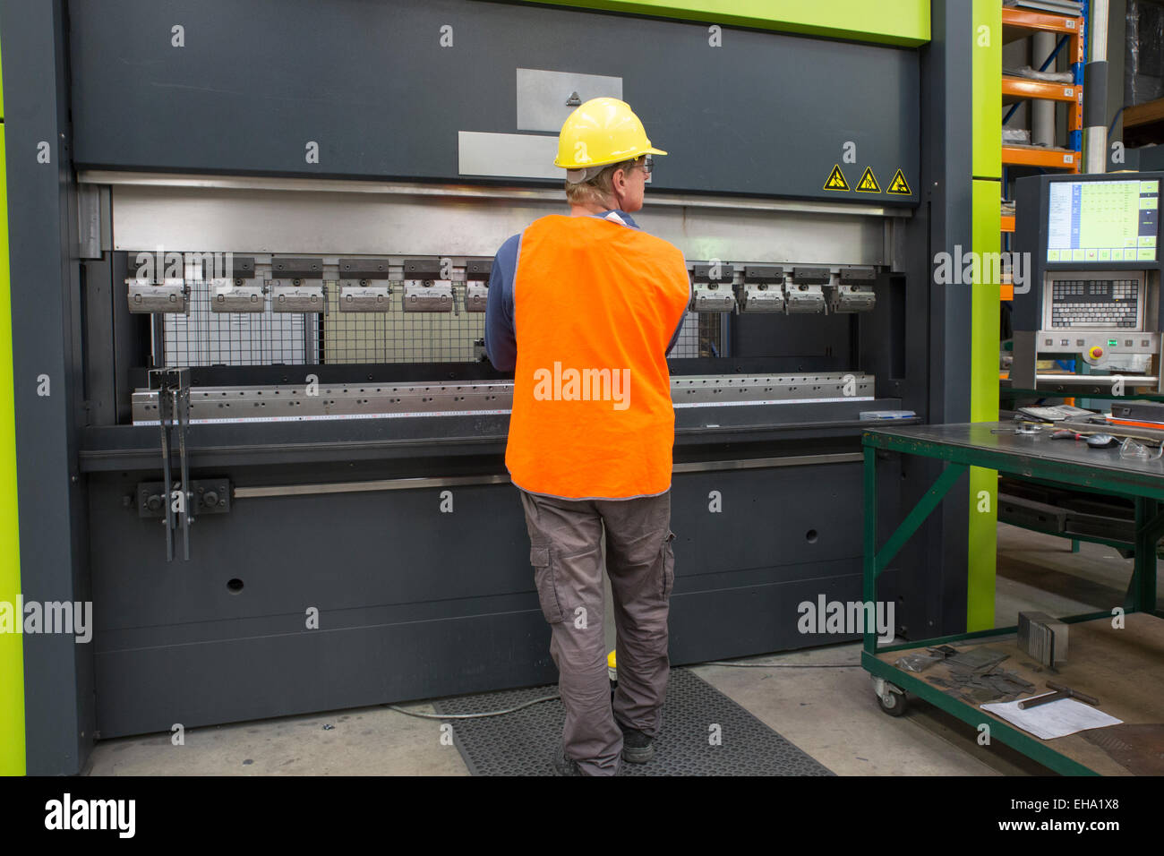 metal industry worker operates CNC brake press machine Stock Photo - Alamy