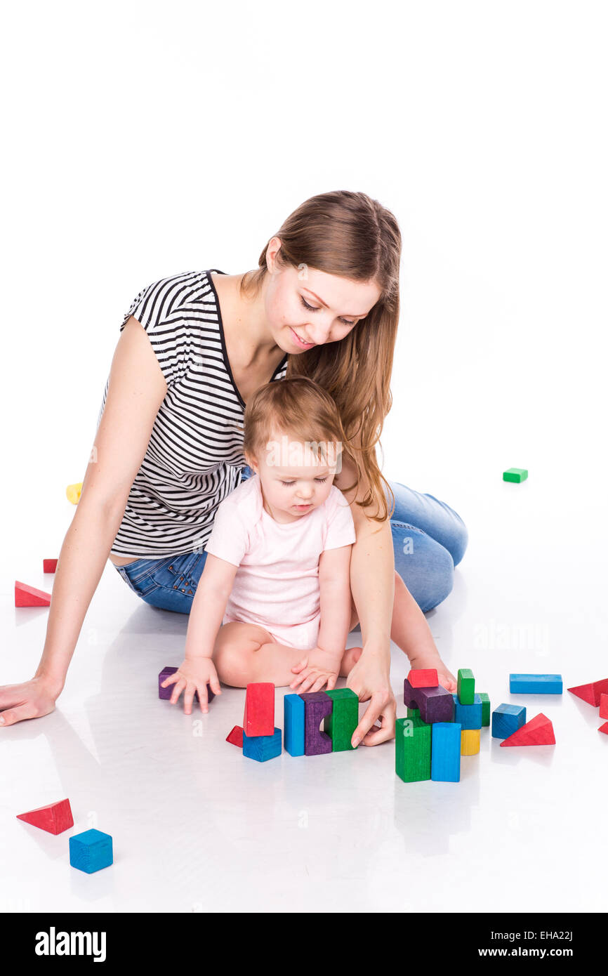 Beautiful baby with mother building a castle with cubes isolated on ...