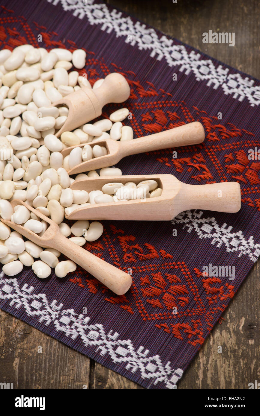 white beans in a wooden bowl on the background of the Ukrainian pattern ...