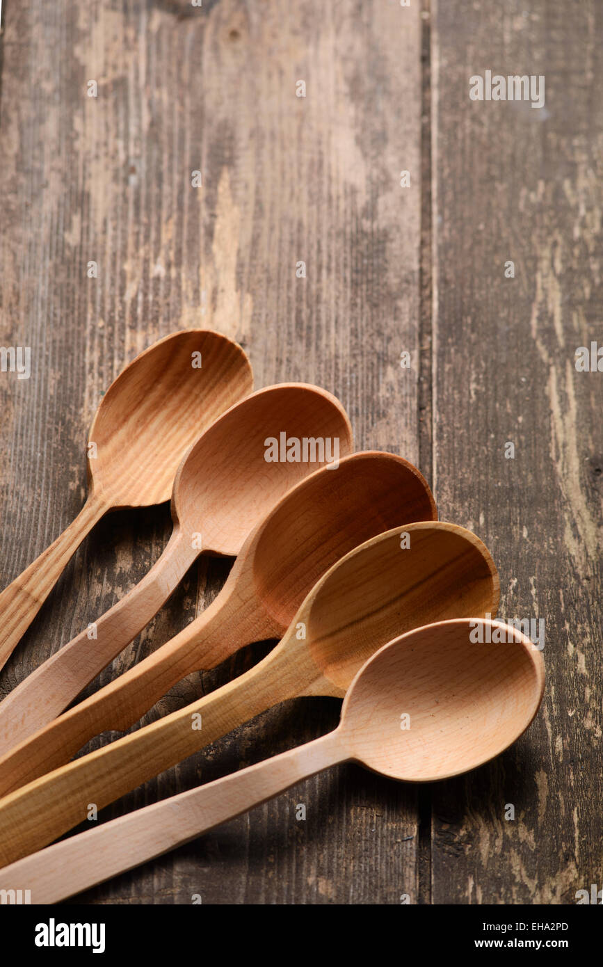 five wooden spoons on a dark wooden background Stock Photo - Alamy