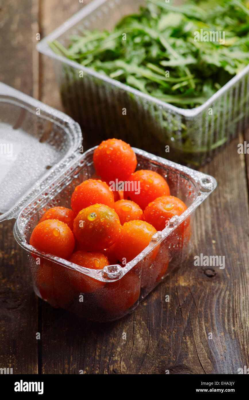 cherry tomatoes in plastic dishes and arugula Stock Photo - Alamy