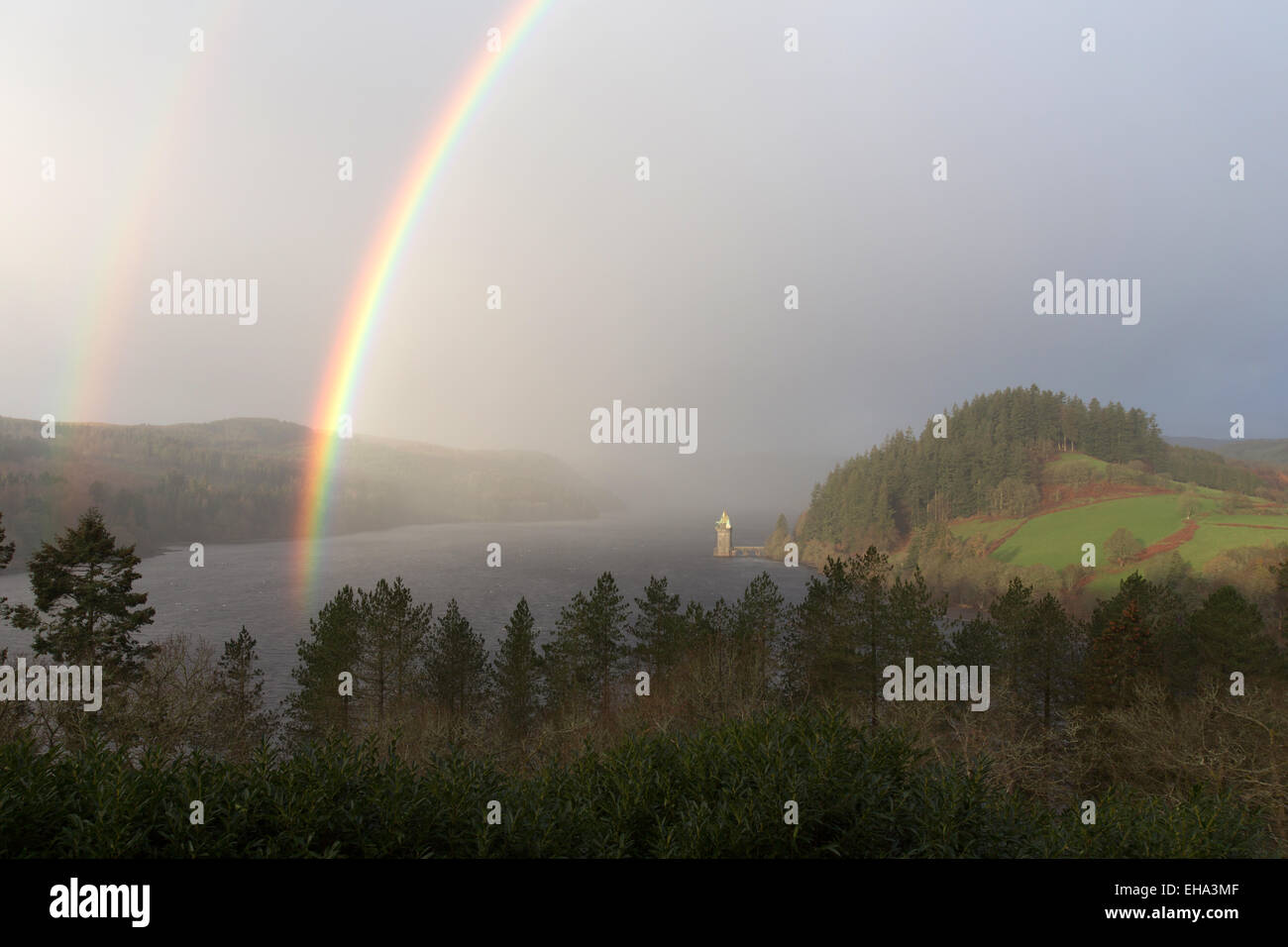Stunning elevated view of a rainbow forming over Lake Vyrnwy, with the ...