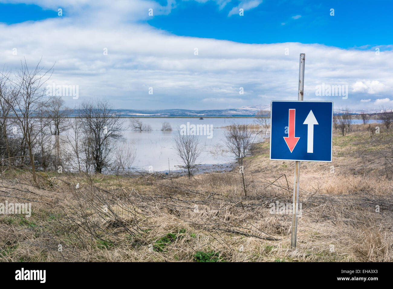 Flood - a natural phenomenon. Beautiful blue sky and road sign with ...