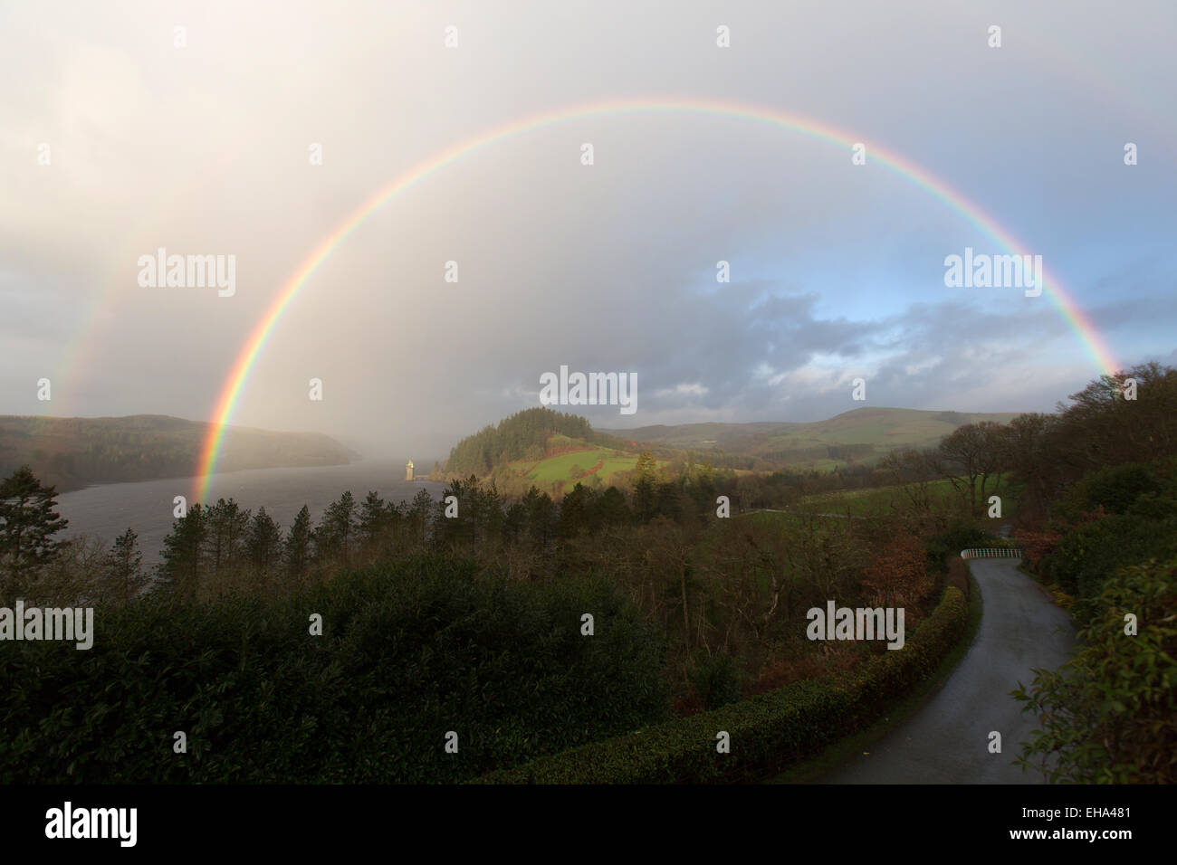 Stunning elevated view of a rainbow forming over Lake Vyrnwy, with the ...