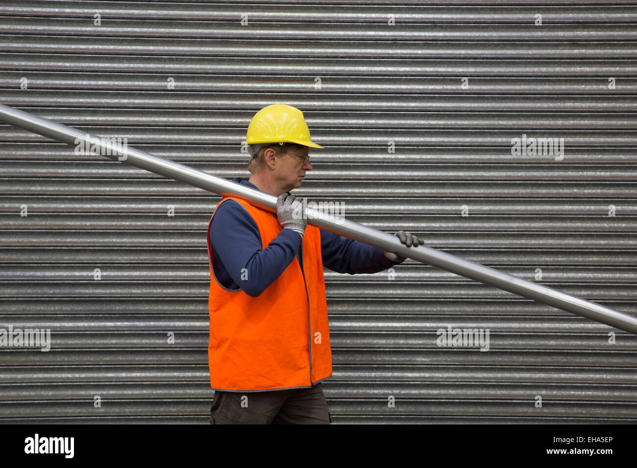 Construction worker with steel pipe Stock Photo - Alamy
