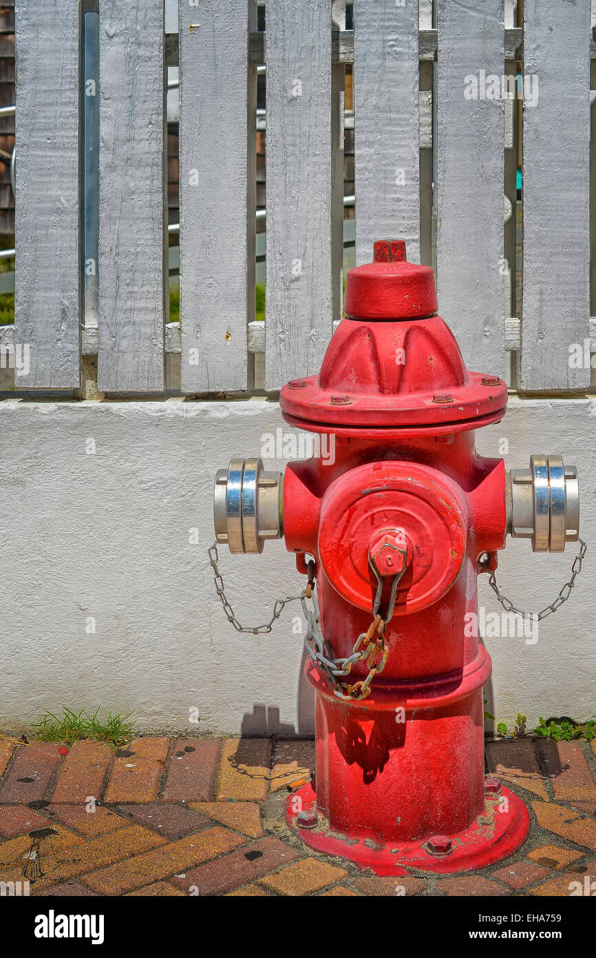 Red fire hydrant in the street with a wooden fence background Stock ...