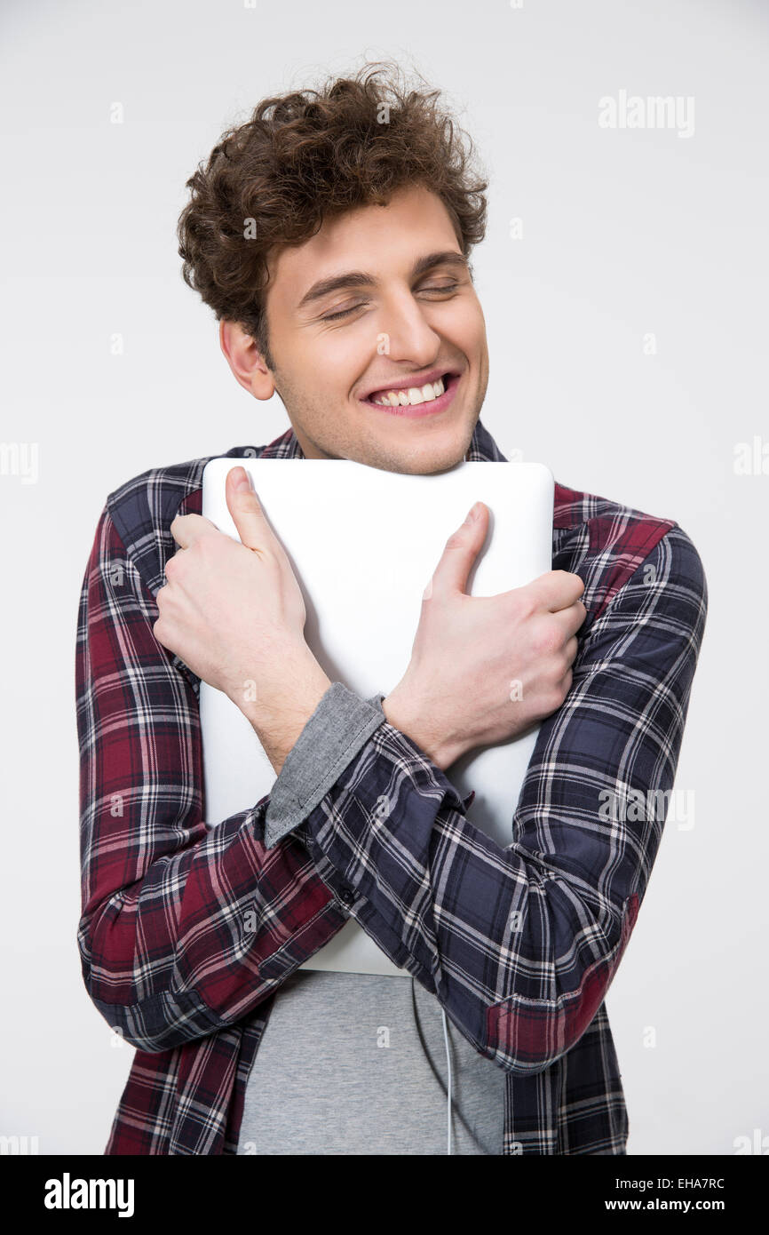 Happy man hugging laptop over gray background Stock Photo - Alamy