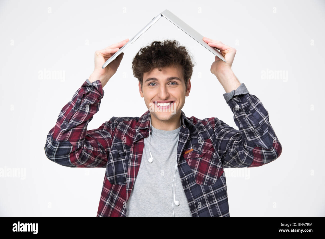 Happy man holding laptop on his head like roof of hous Stock Photo - Alamy