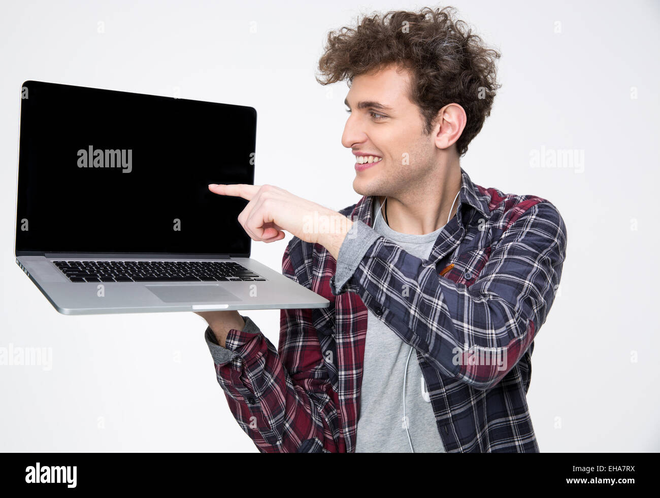 Young casual man pointing on the laptop screen over gray background ...