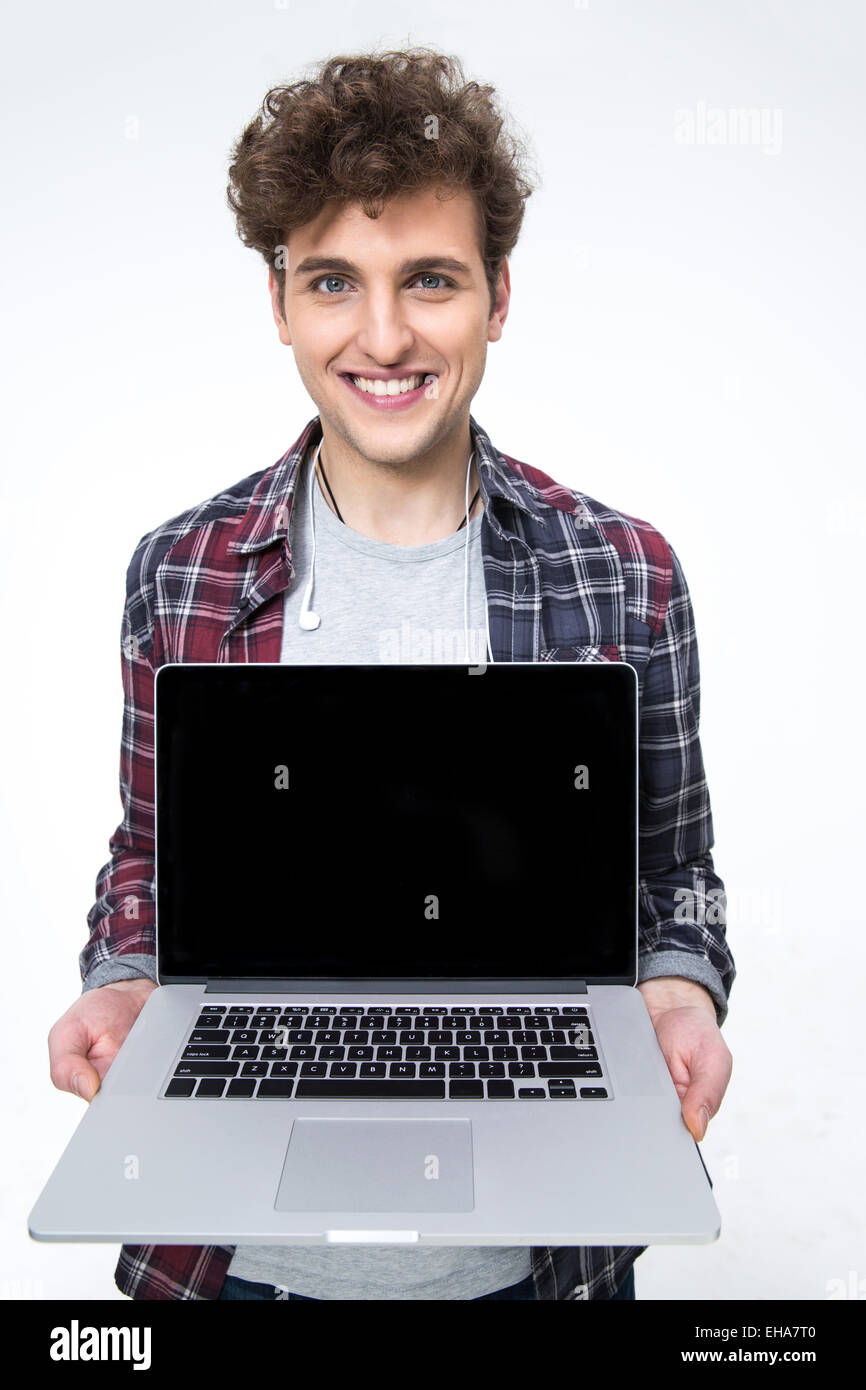Smiling young man showing laptop screen over gray background Stock ...